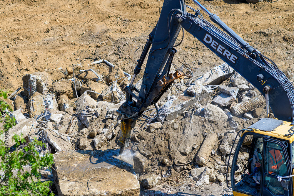 John Deere Excavator with a Hydraulic Hammer Attachment Breaks up a ...