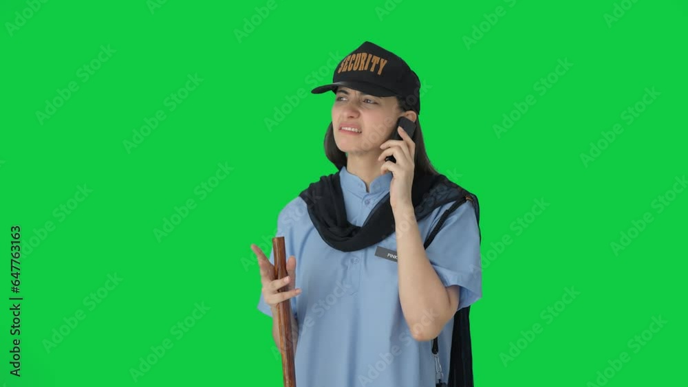 Confused Indian female security guard talking to someone on call Green ...