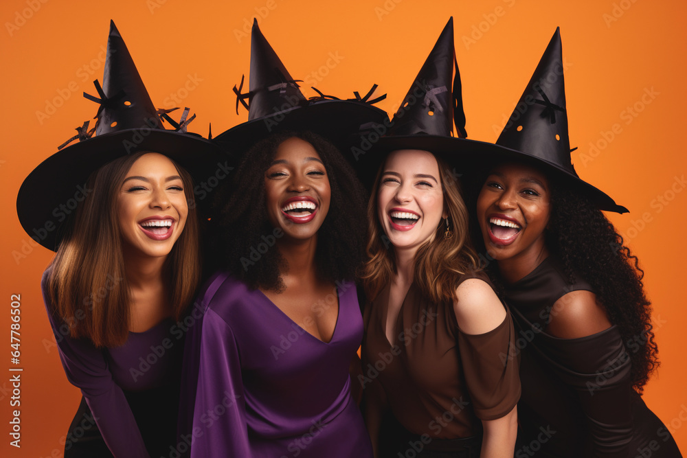 diverse group of young women in Halloween witch costumes on orange ...