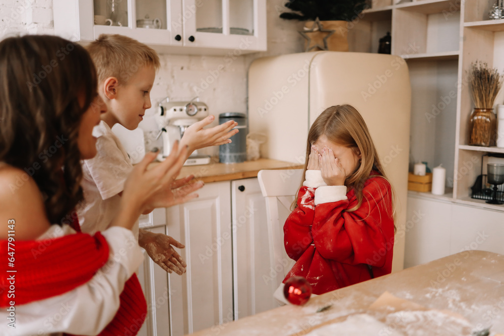 Parents and brother shout and scold a little roaring girl covering her ...