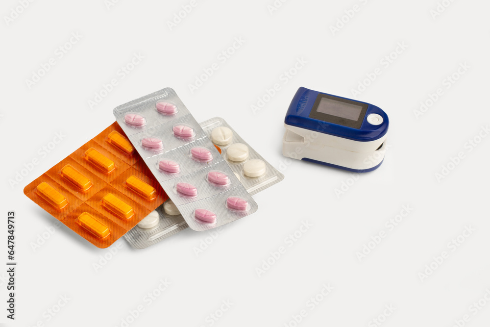 Pastillas y medicamentos junto a un medidor de pulso cardíaco sobre un ... Pastillas y medicamentos junto a un medidor de pulso cardíaco sobre un ...