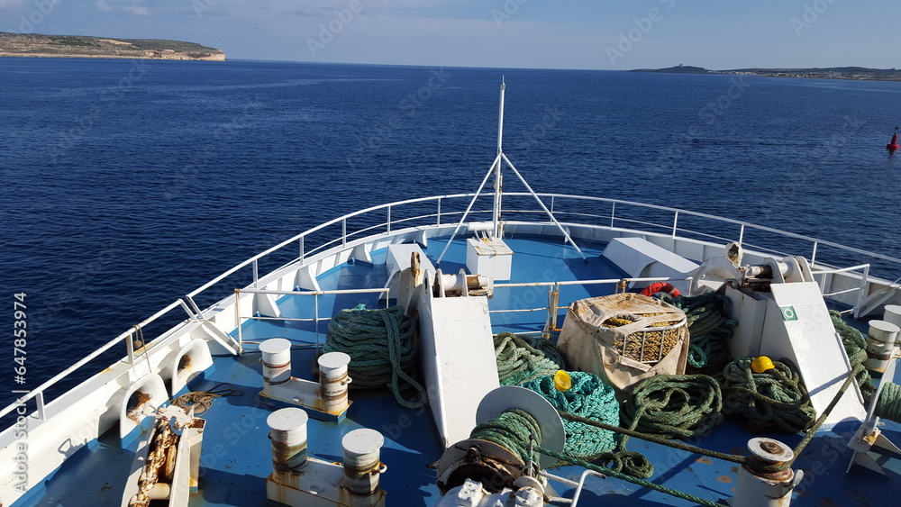 The bow of a boat slices through the open water, leaving a trail of ...