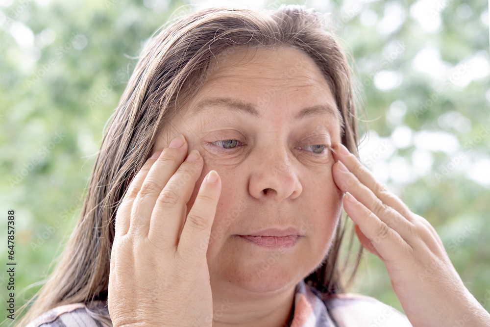close-up of mature charismatic woman 50 years holding hand over eyes ...