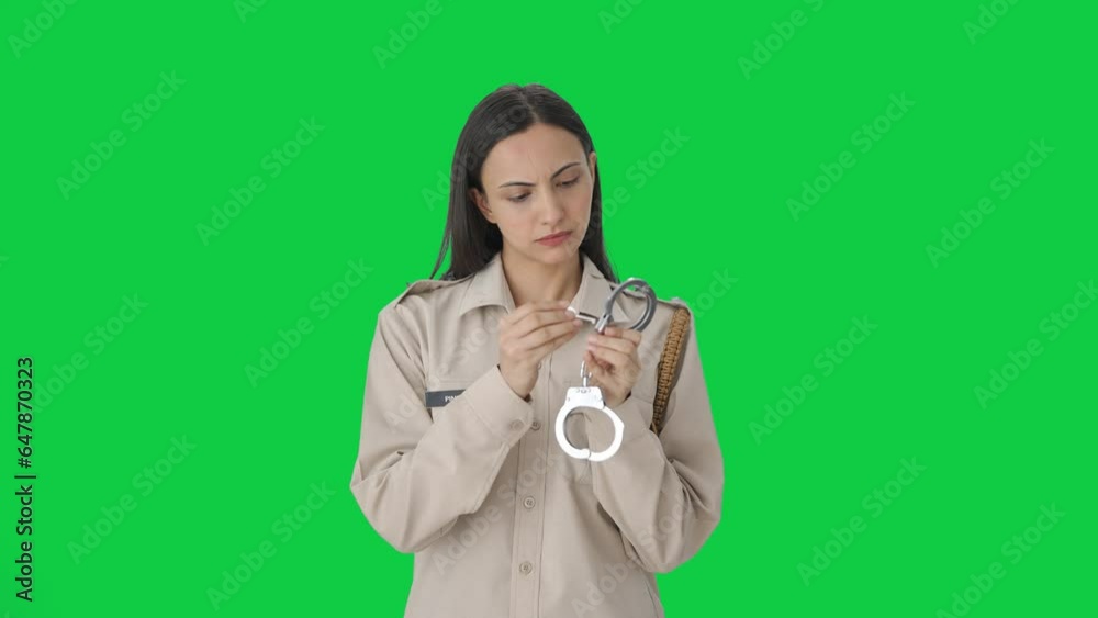 Indian female police officer inspecting handcuffs Green screen vídeo do ...