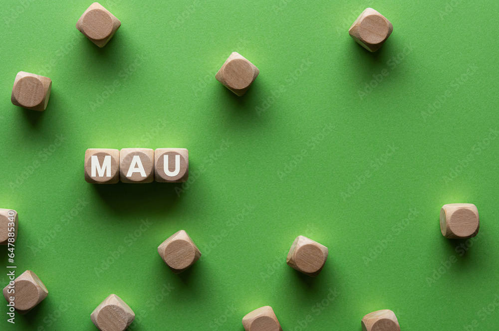 There is wood cube with the word MAU. It is an abbreviation for Monthly ...