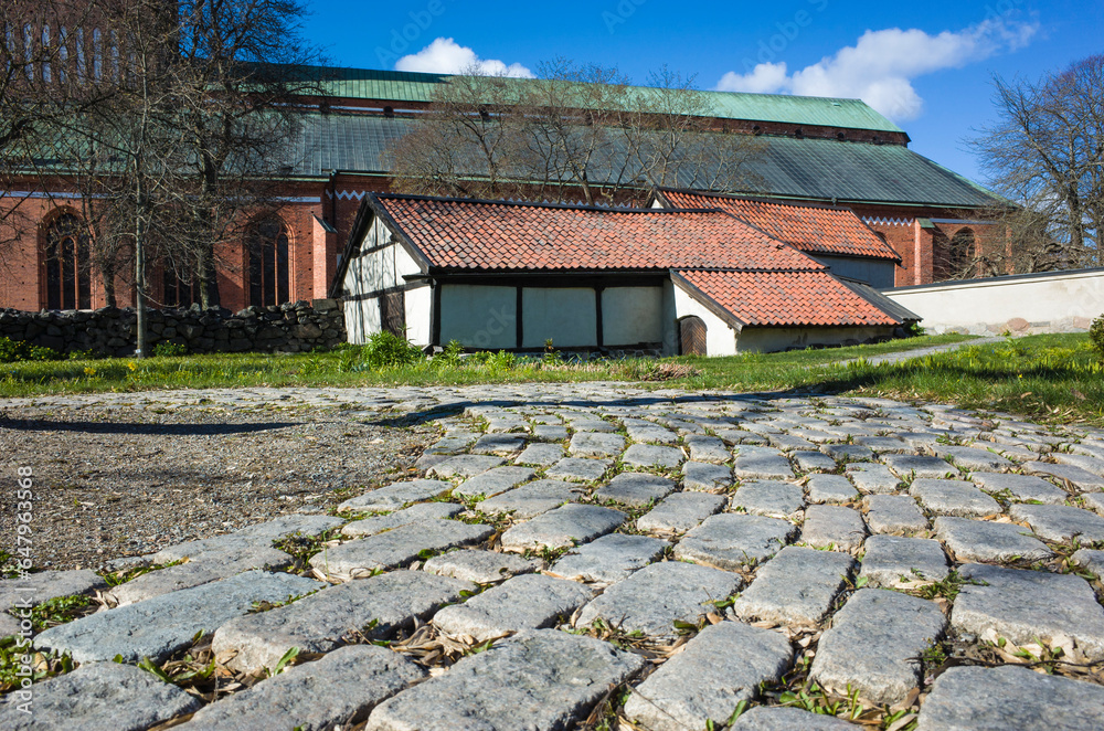 Paved walkway leads to old one-story building with red tiled roof ...