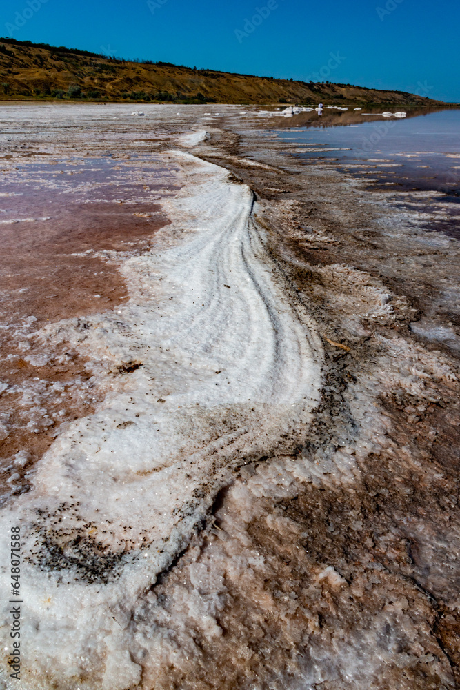 Salt Lake. Self-settling sodium chloride salt on rocks near the shore ...