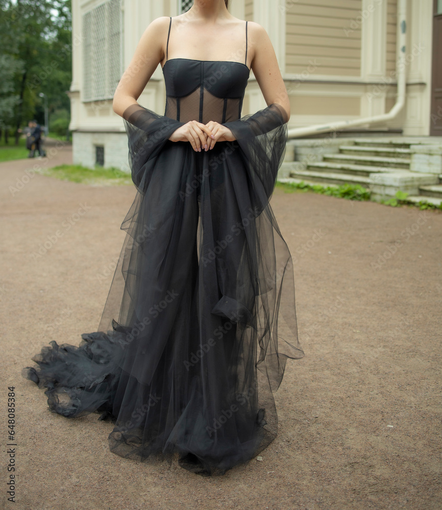 A 30-year-old girl in a black transparent revealing dress walks down ...