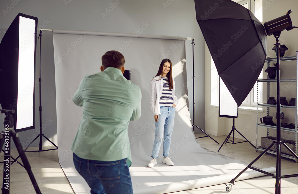 Male photographer shooting model in modern lighting studio. Rare view ...