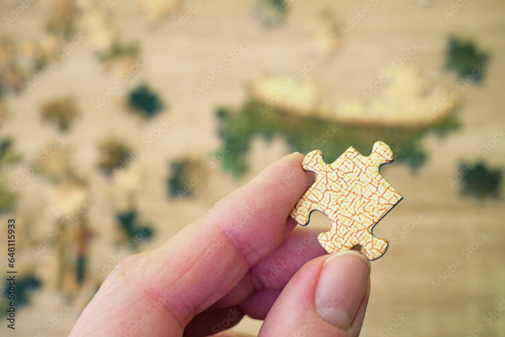 Hand holding one puzzle on many sorting by color and shape background ...