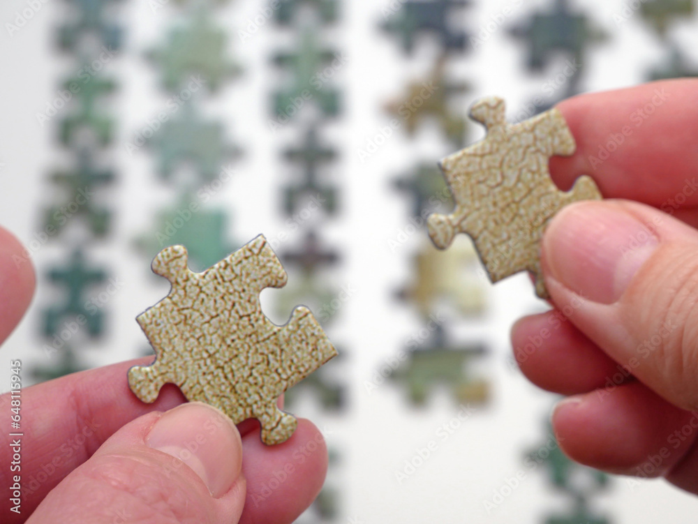 Hand holding one puzzle on many sorting by color and shape background ...