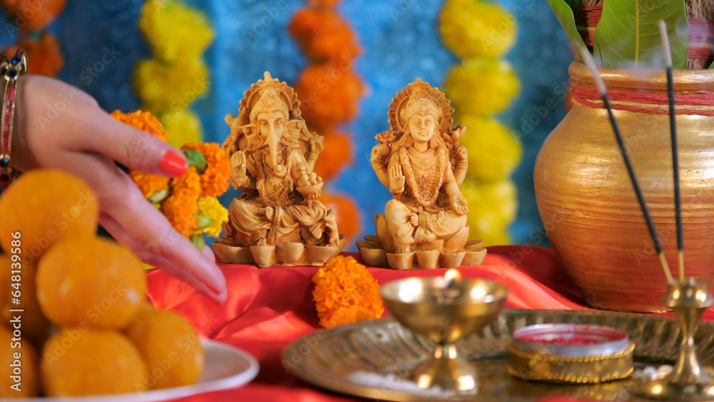 Lady offering marigold flowers to Lord Ganesha and Devi Laxshmi on ...