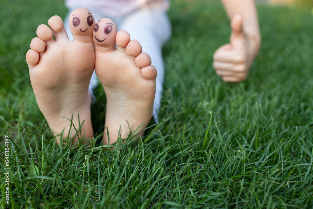Children's bare feet on green grass. cheerful positive atmosphere ...