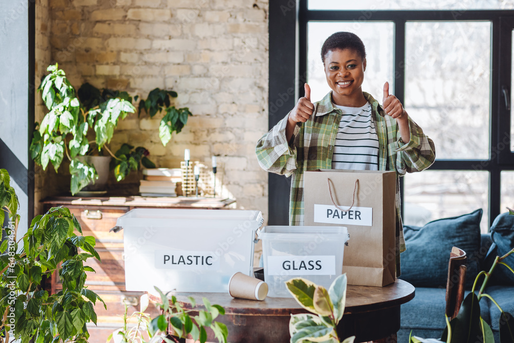 Young university student is managing waste sorting at home, smiling ...