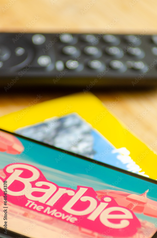 Barbie the movie logo seen displayed on a smartphone and a tv remote ...