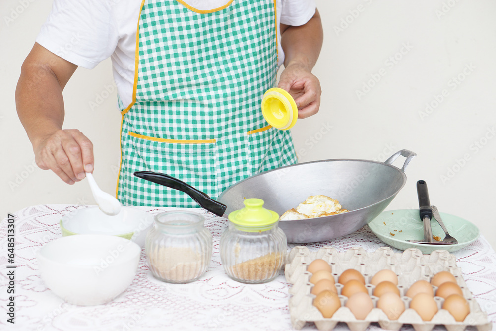 Foto de Close up man is cooking, fried eggs menu, pan , tray of eggs ...