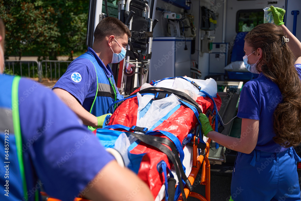 Ambulance team transports the patient on special stretcher to ambulance ...