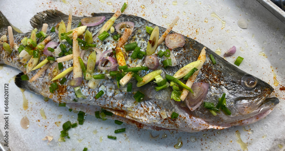 Marinating barramundi fish (Lates calcarifer, also known as Asian sea ...