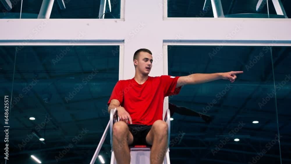 young professional umpire in the game of tennis sitting on the ...
