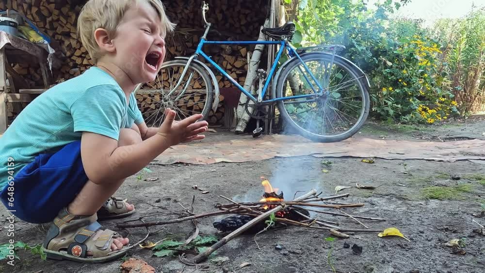 An upset, unhappy child is crying by the fire. Concepts of nervous ...