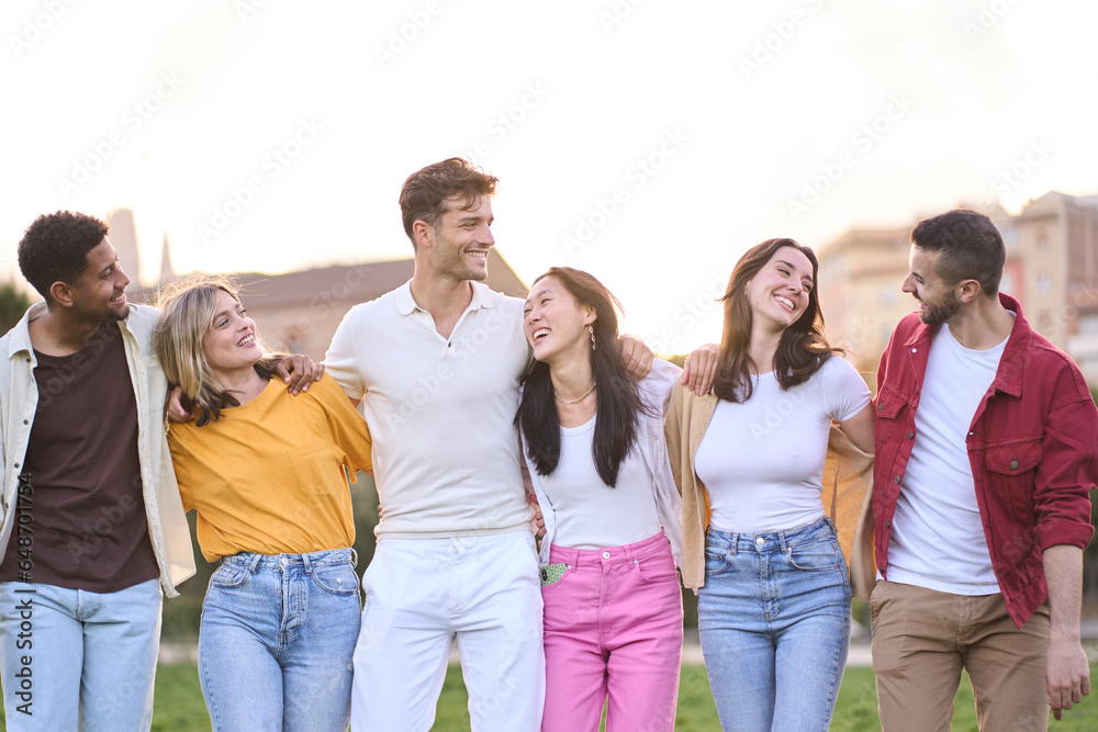 Multirracial group of cheerful young friends together at the park ...