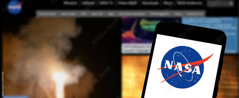 The NASA logo on the screen of a Smartphone with a blurred background ...