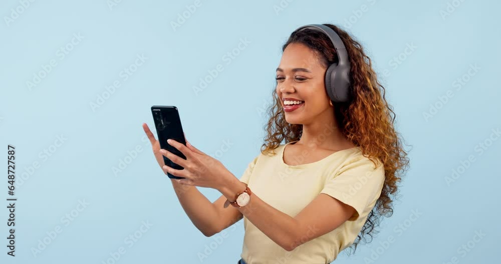 Woman, scroll social media with headphones and smartphone in studio ...