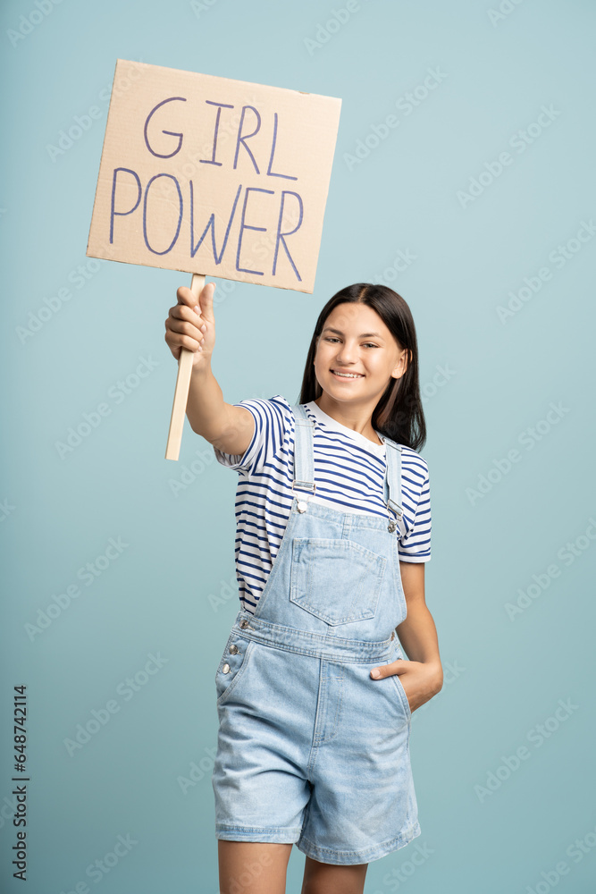 Positive energetic girl holding front of him GIRL POWER placard ...