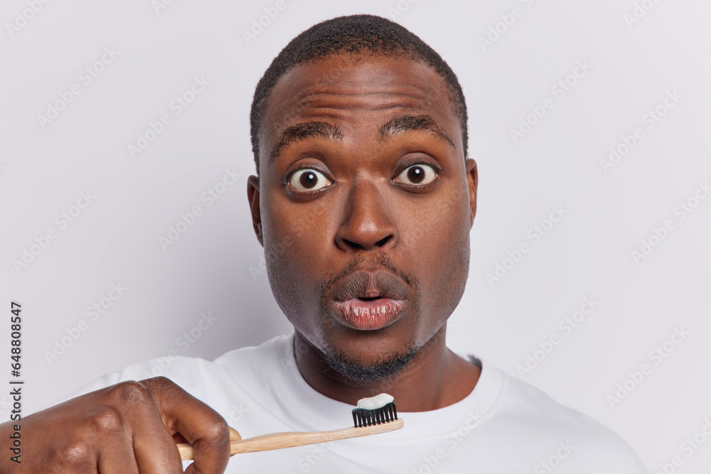 Photo of dark skinned man brushing his teeth with toothbrush doing ...