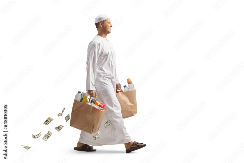 Arab man in ethnic clothes walking and carrying grocery bags and money ...