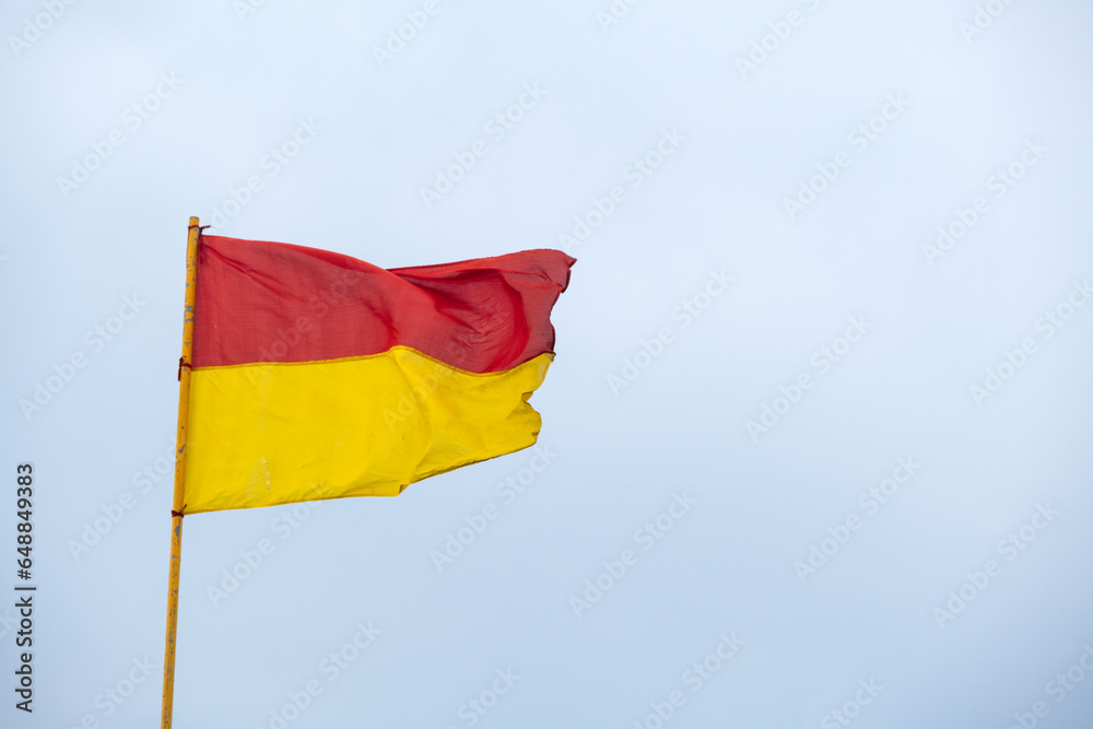 Red and yellow warning flag weaving at sea beach: Recommended swimming ...