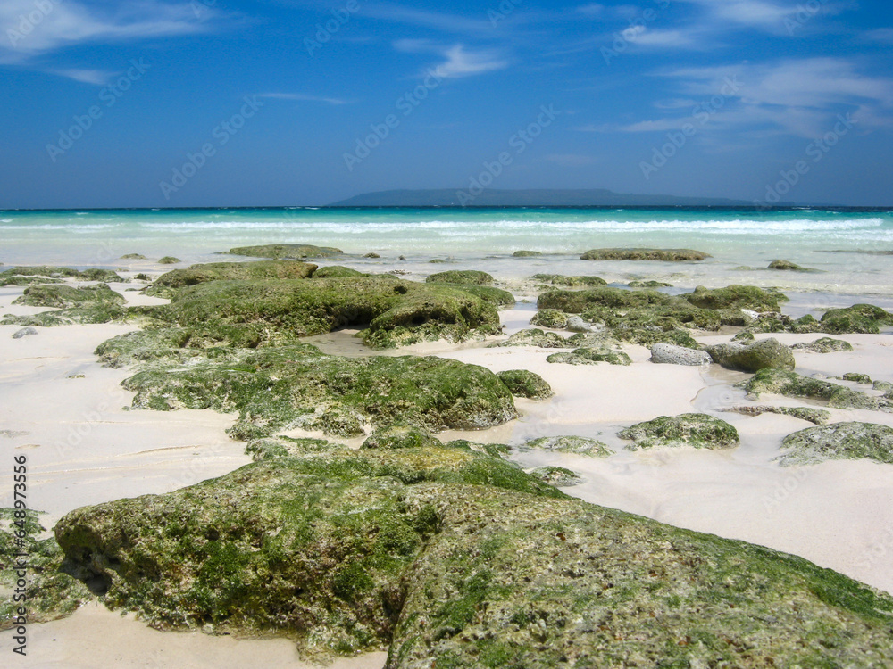 The view when former coral reef rocks appear on the beach when the sea ...