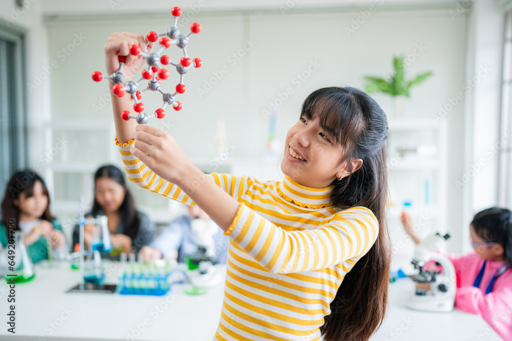 Little girl having fun time with holding molecular model learning ...