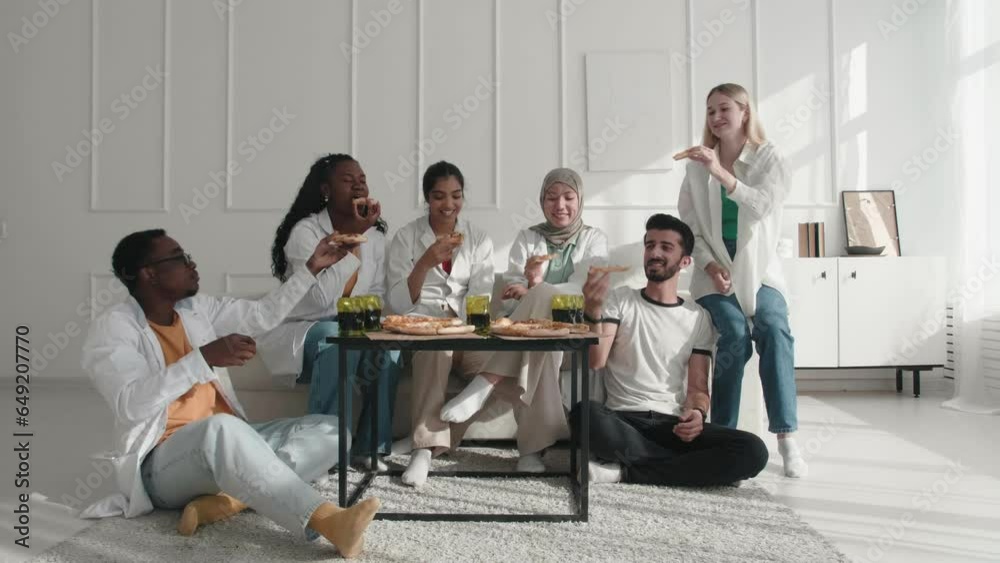 Happy young doctors interns having a break with pizza, lunch time ...