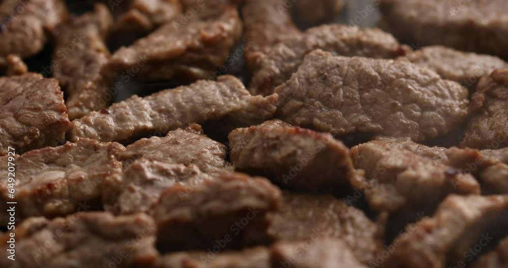 Sliced pieces of meat are fried in a frying pan. Roasting beef in a pan ...