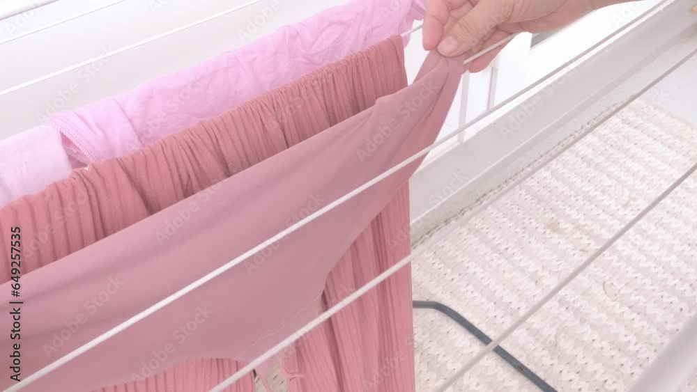 female hands hang wet clothes on dryer to dry, wet laundry hanging and ...