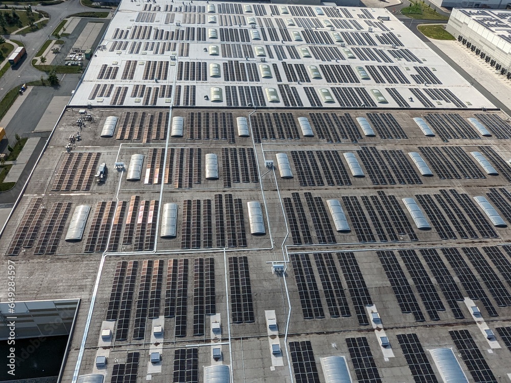 Solar panels installed on a roof of a large industrial building or a ...