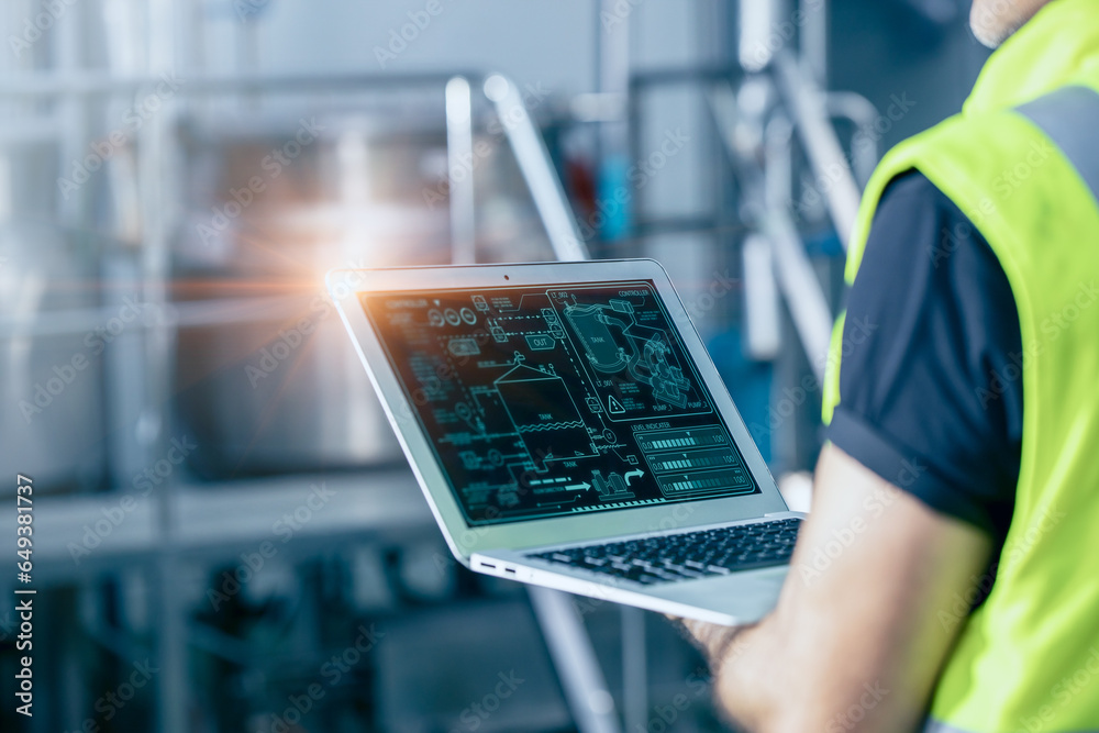 Engineer with laptop high technology software for industrial factory ...