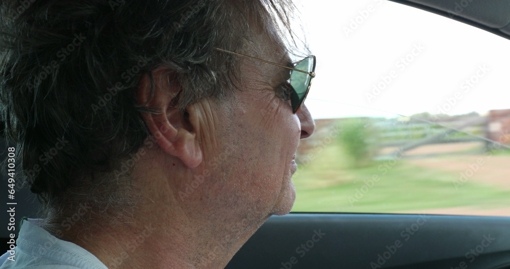 Profile of older man face driving on road with landscape passing by ...