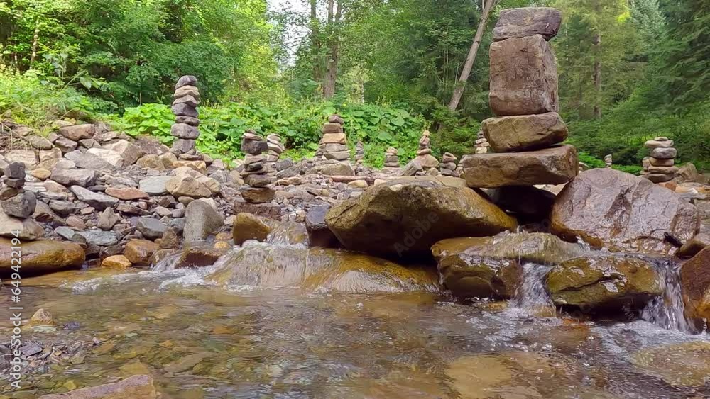 Stone pyramids on the bank of a mountain river were built by tourists ...