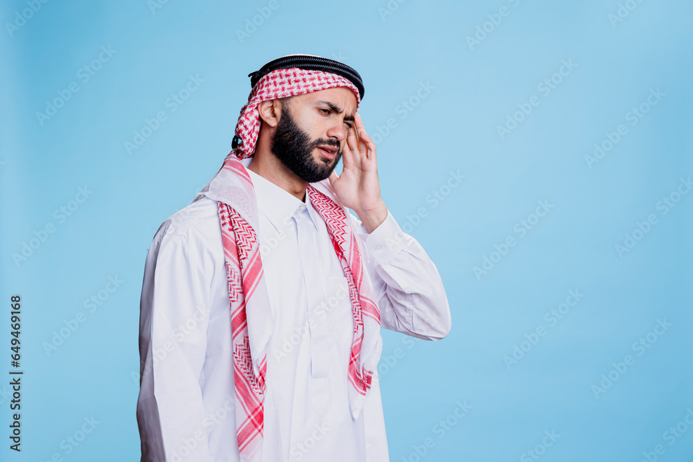 Muslim man wearing traditional clothes suffering from migraine and ...