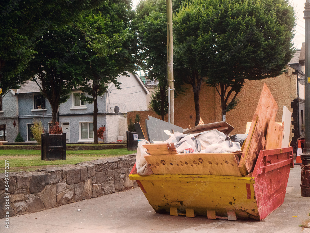 Yellow metal skip full of house repair junk ready for pick up in city ...