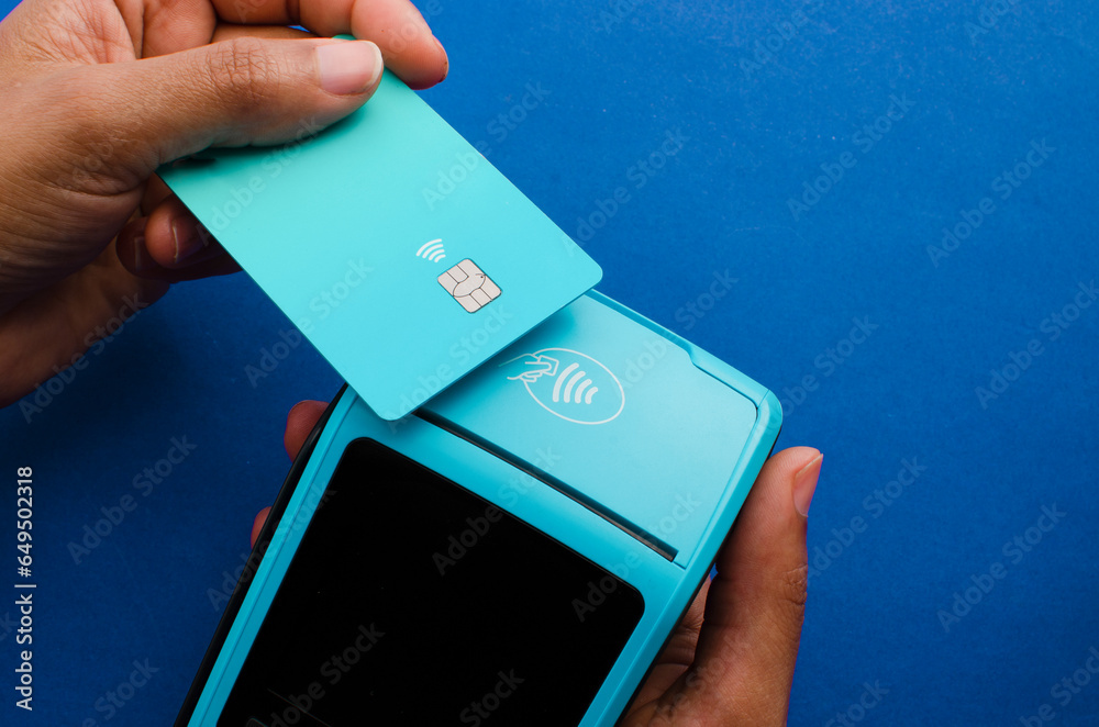 Foto de Closeup of hands holding a modern credit card payment device ...