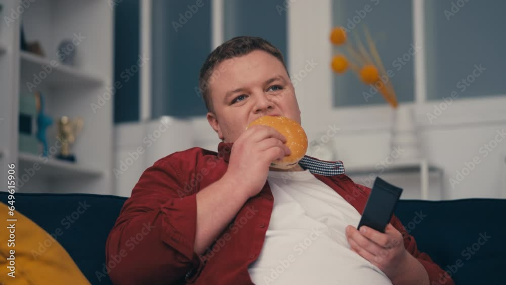 Lazy young man eating junk food and watching tv on couch, unhealthy ...