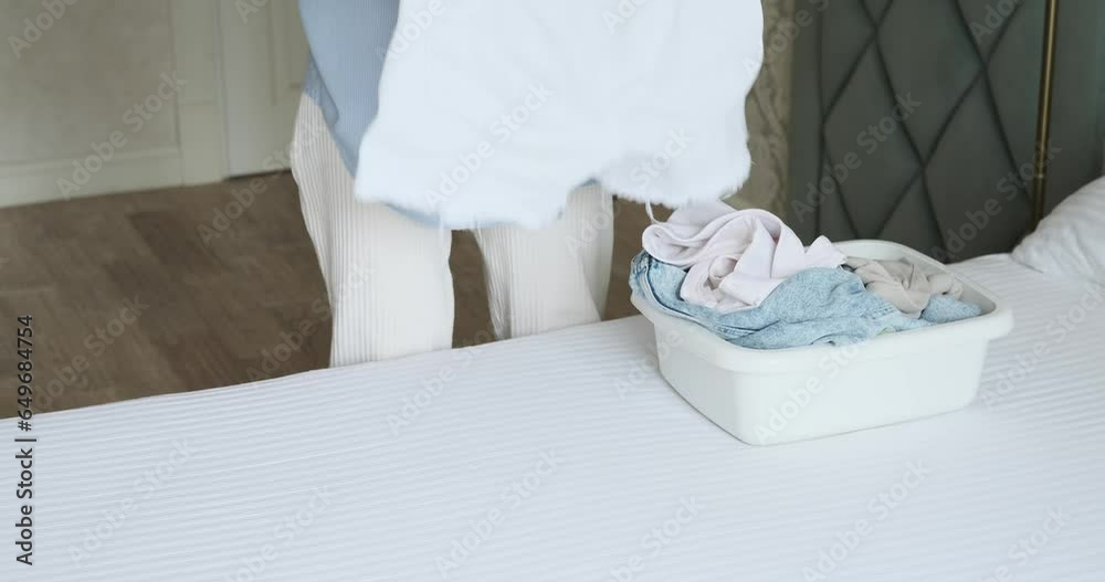 With a methodical approach, a woman neatly folds freshly laundered ...