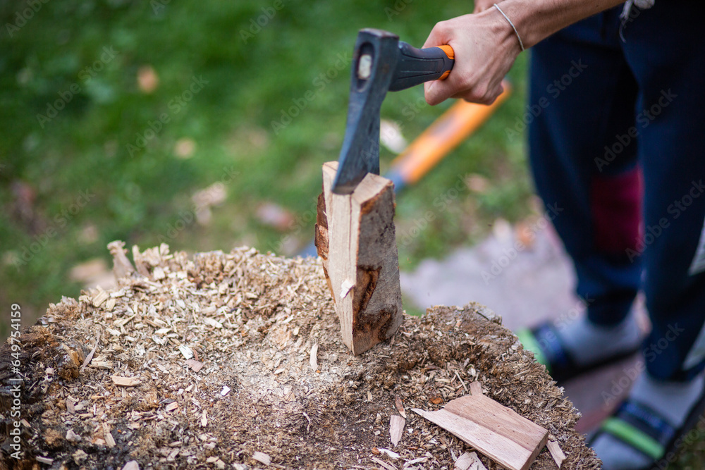 A person splitting wood with an axe with only their hands showing ...