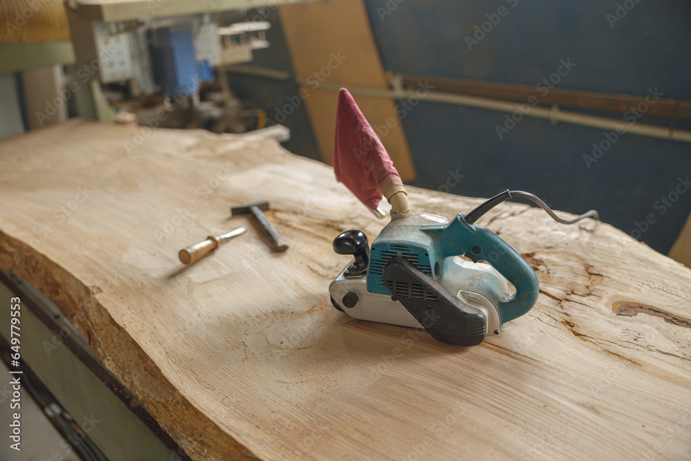 Professional electric sander, chisel and hammer is lying on wooden ...