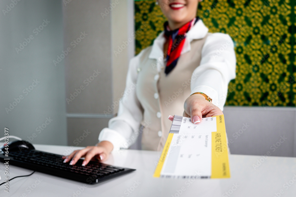 Happy smiling Asian female passenger service agent giving boarding pass ...