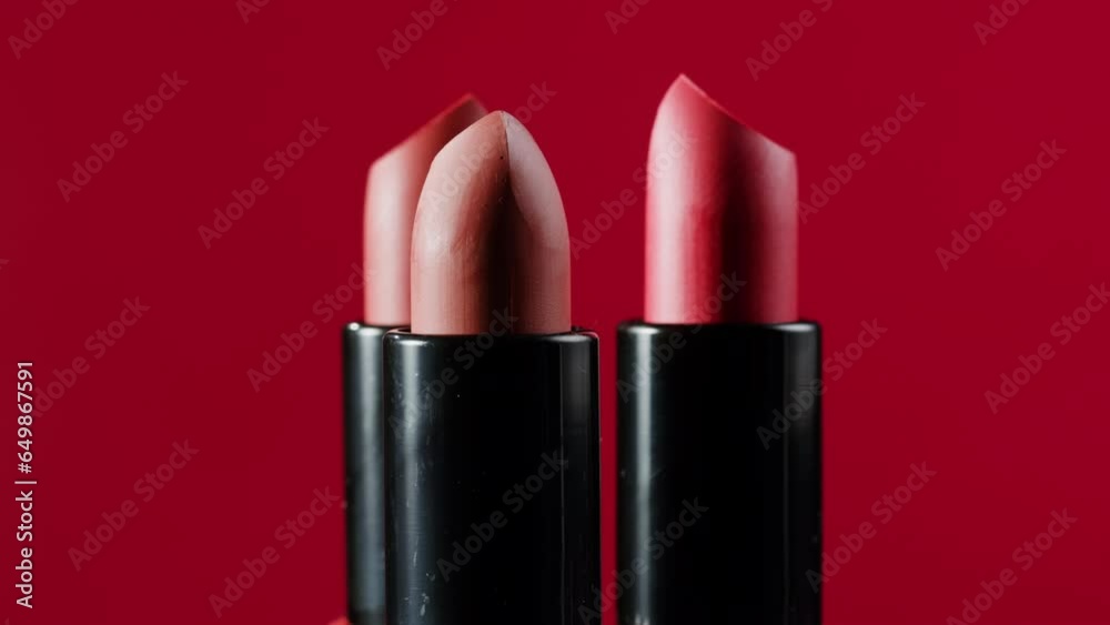 Red lipsticks make up close up background with smoke and water drops ...