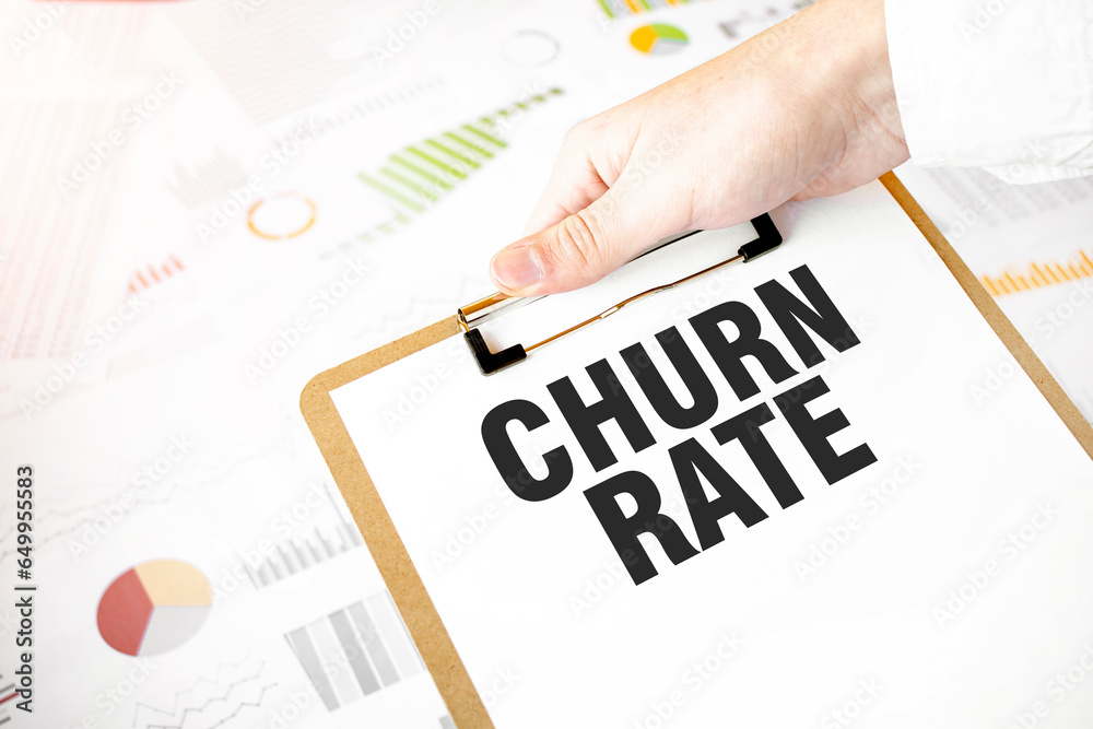Text CHURN RATE on white paper plate in businessman hands with ...